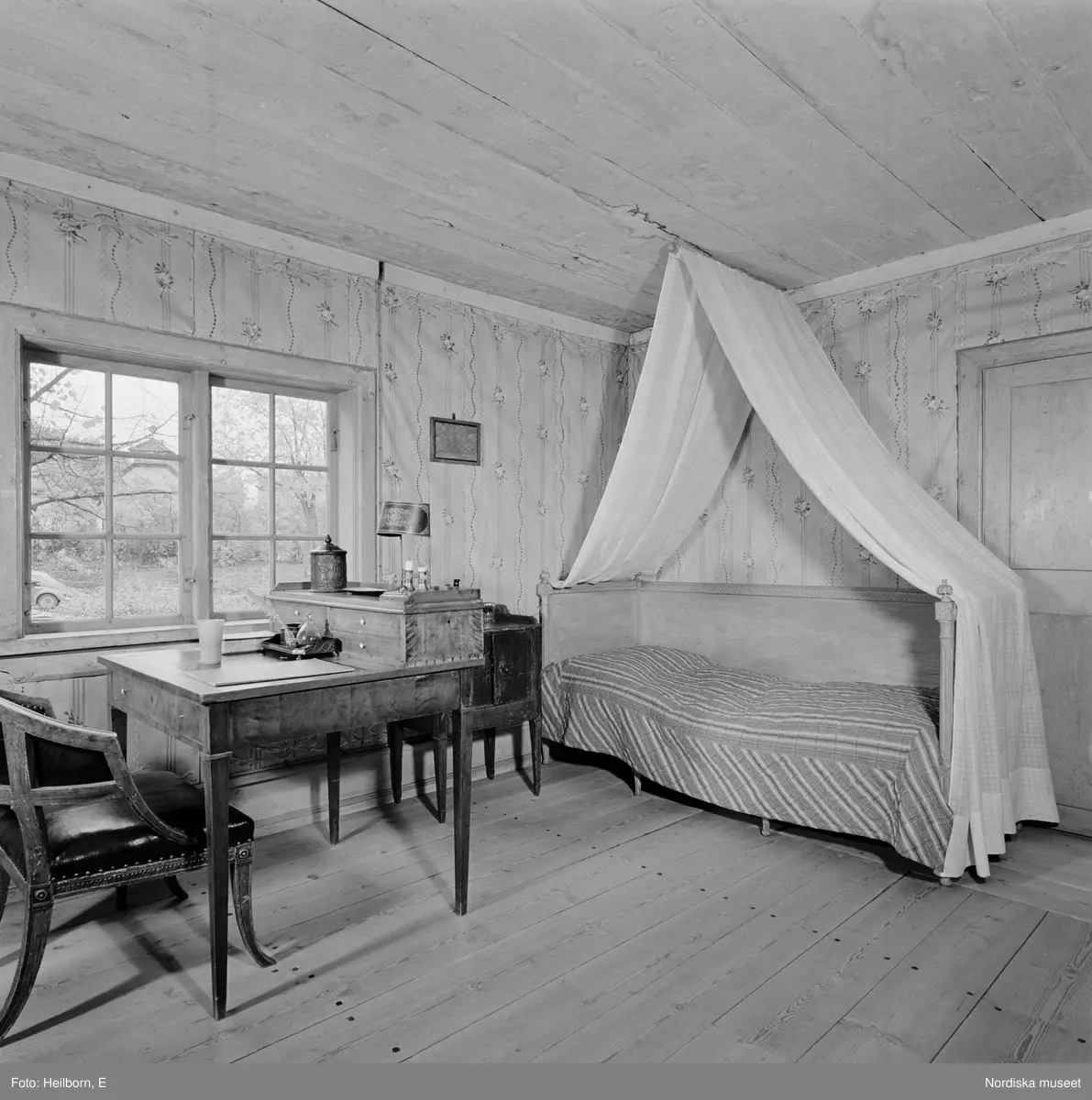 Interiör från Boktryckeriet på Skansen. På bilden ett skrivbord med stål och en säng med ...