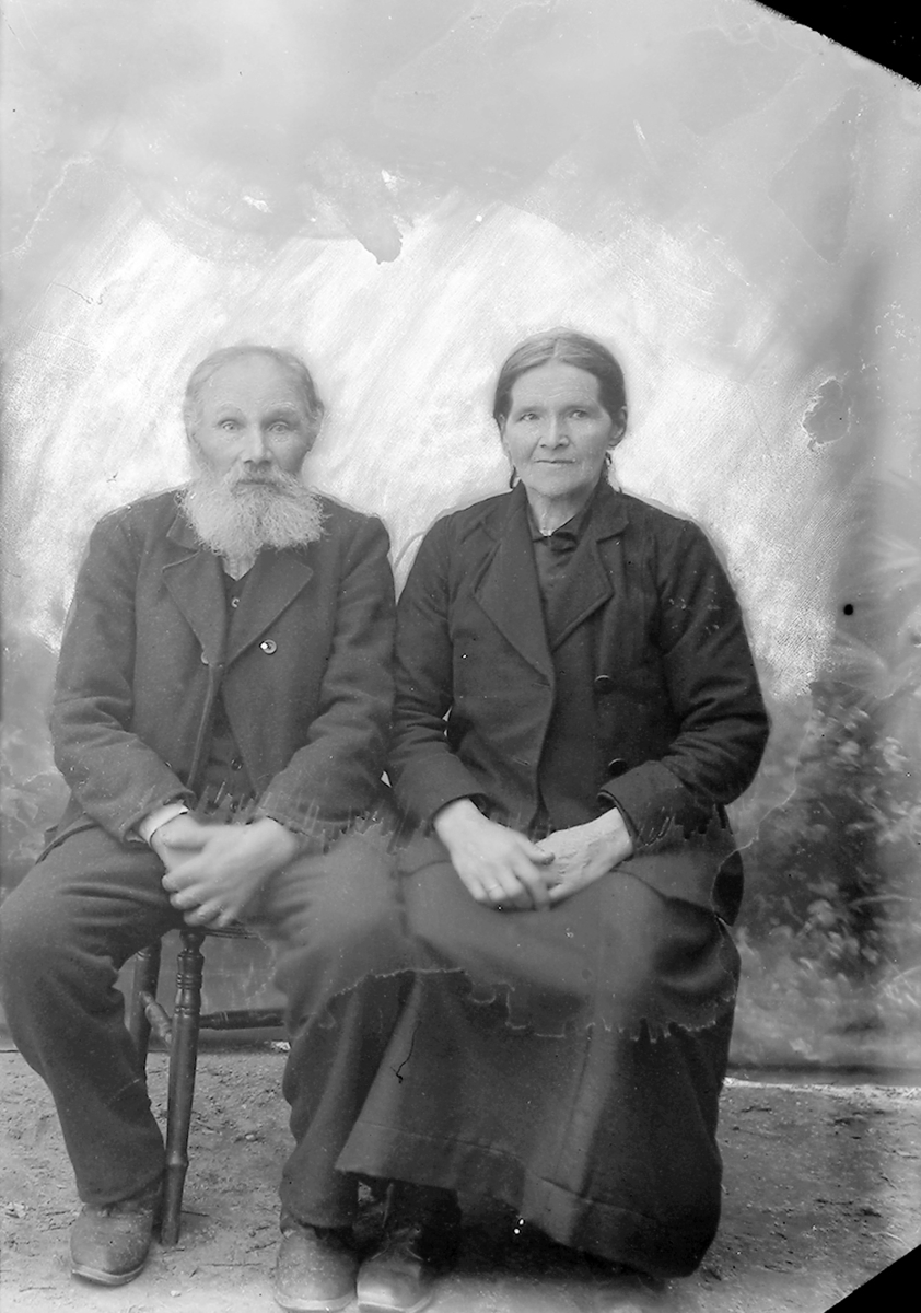 Portrett. Par i 70-80-åra. Begge sitter. Mannen med skjegg. Bildet er ...