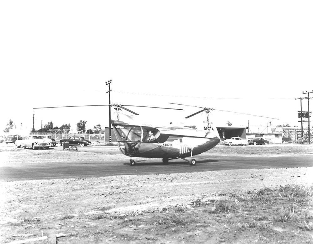 1 helikopter på bakken. McCulloch MC-4. 1 person inne i cockpiten ...