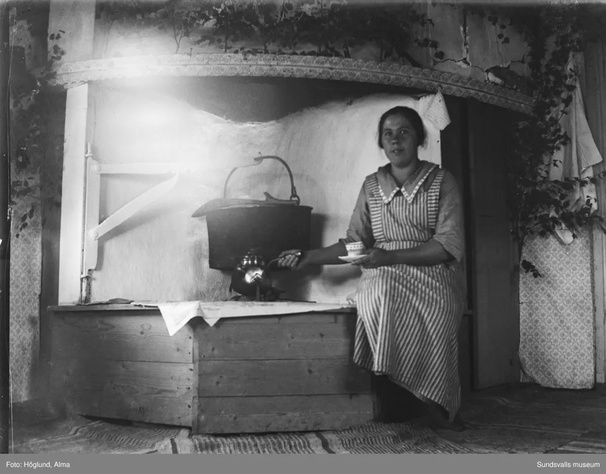 Olga Lundgren vid eldstaden i Kullboan. Hon var bopiga hos Gotthard Lundgren, Gräfte ...