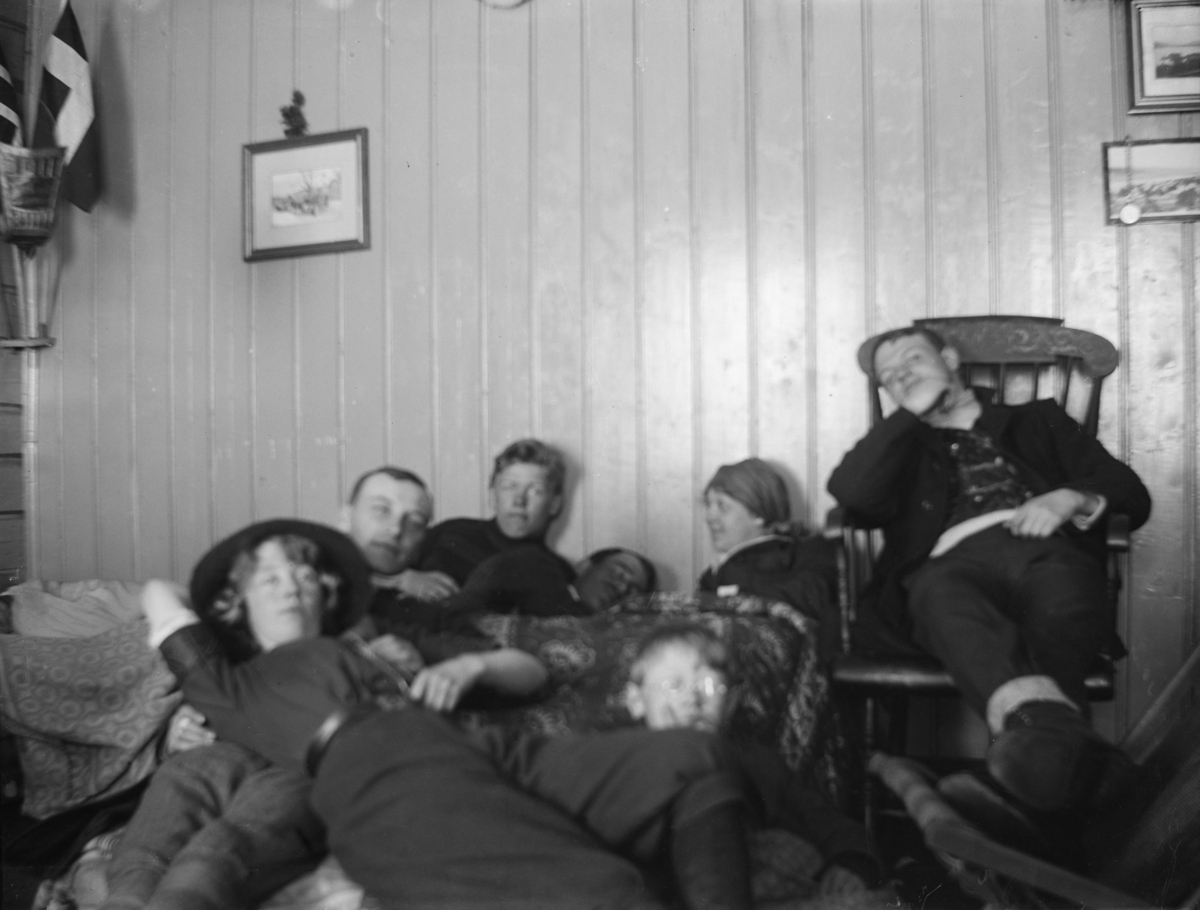 Glassplate Flere personer som slapper av i ei seng og en stol i et rom ...