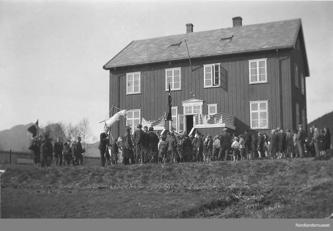Mange barn og noen voksne midt på bildet. Store og små flagg. En mann ...