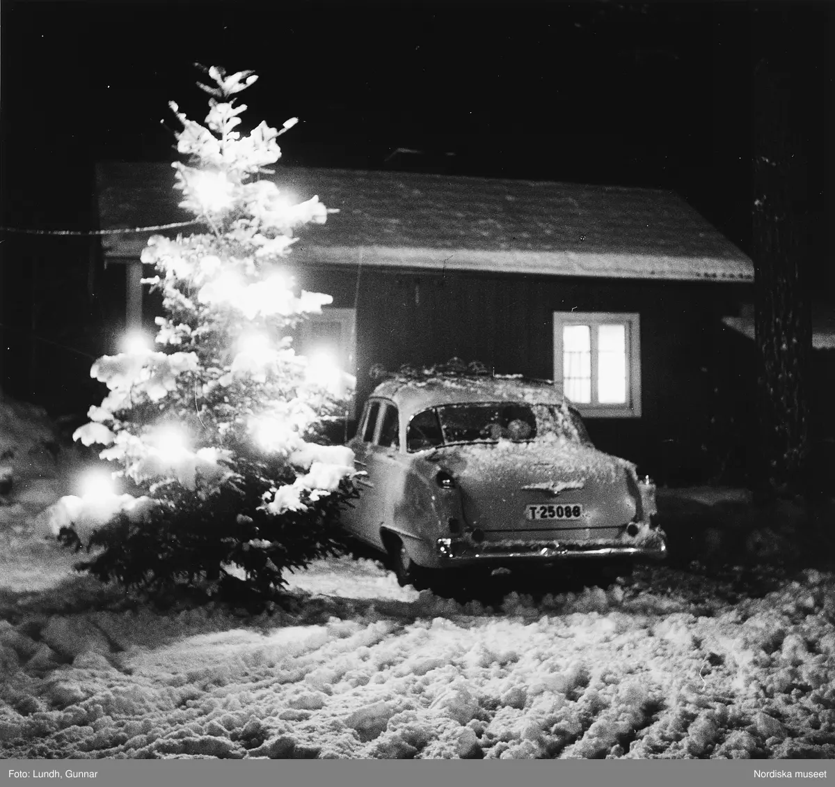 Nattbild exteriör av ett hus med en parkerad Opel Kapitän bredvid en ...