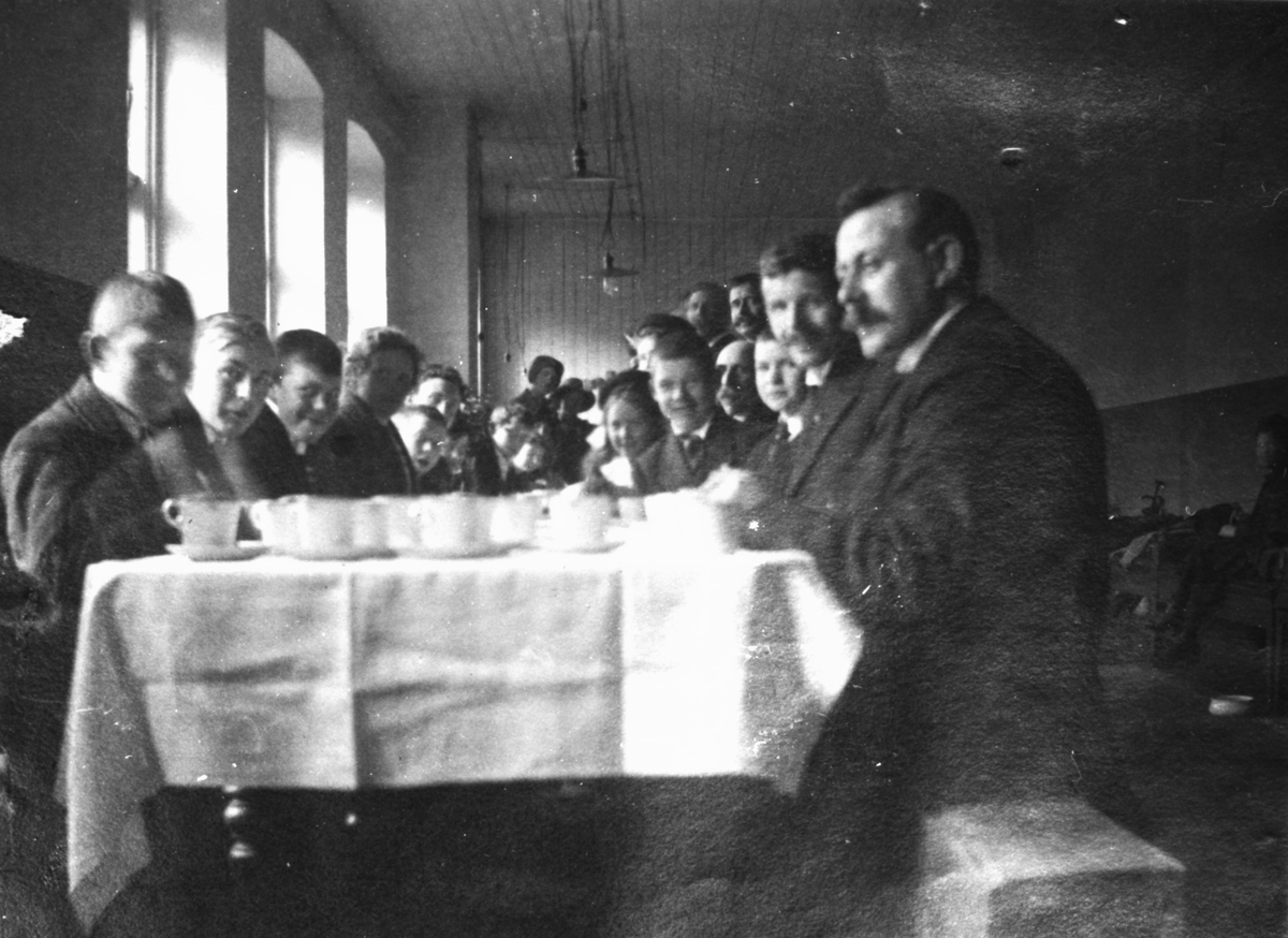 En stor gruppe mennesker er samlet rundt et spisebord på Stranda Hotell ...