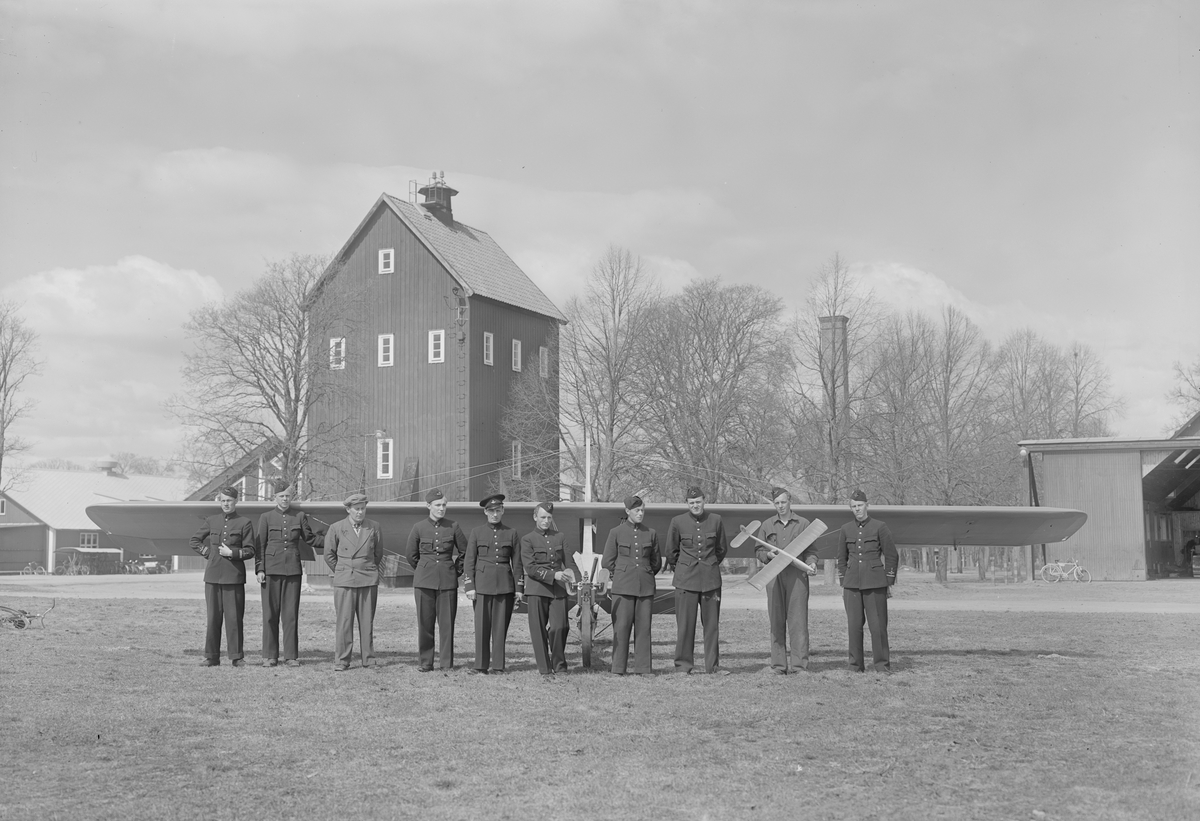 Porträttfotografi av militärer och civilklädda män framför ett ...
