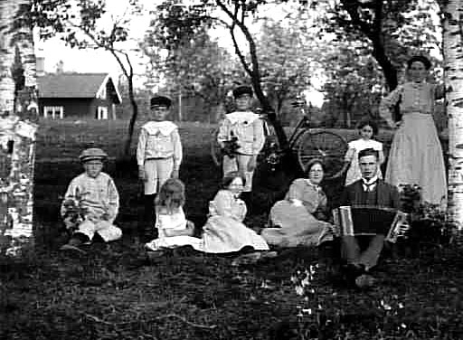 EN MAN SPELAR DRAGSPEL FÖR KVINNOR OCH BARN SOM LIGGER OCH SITTER I ...