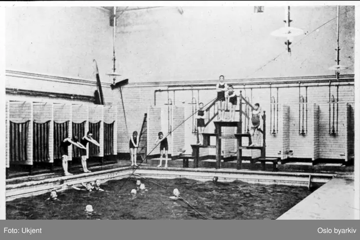 Bad. Basseng og stupebrett, dusjer på bassengkanten. Gutter som stuper ...