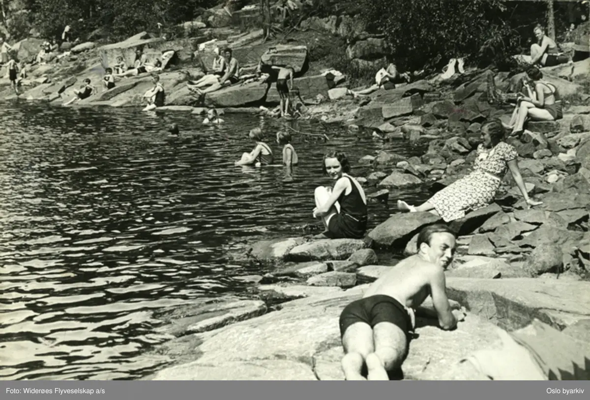 Sol og bad ved Bunnefjordens østre side. Skog og steinete område langs ...